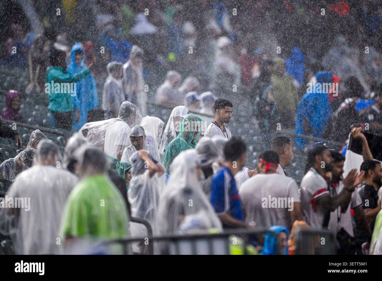 Spectators wears poncho to protect from the rain during the FIFA World ...