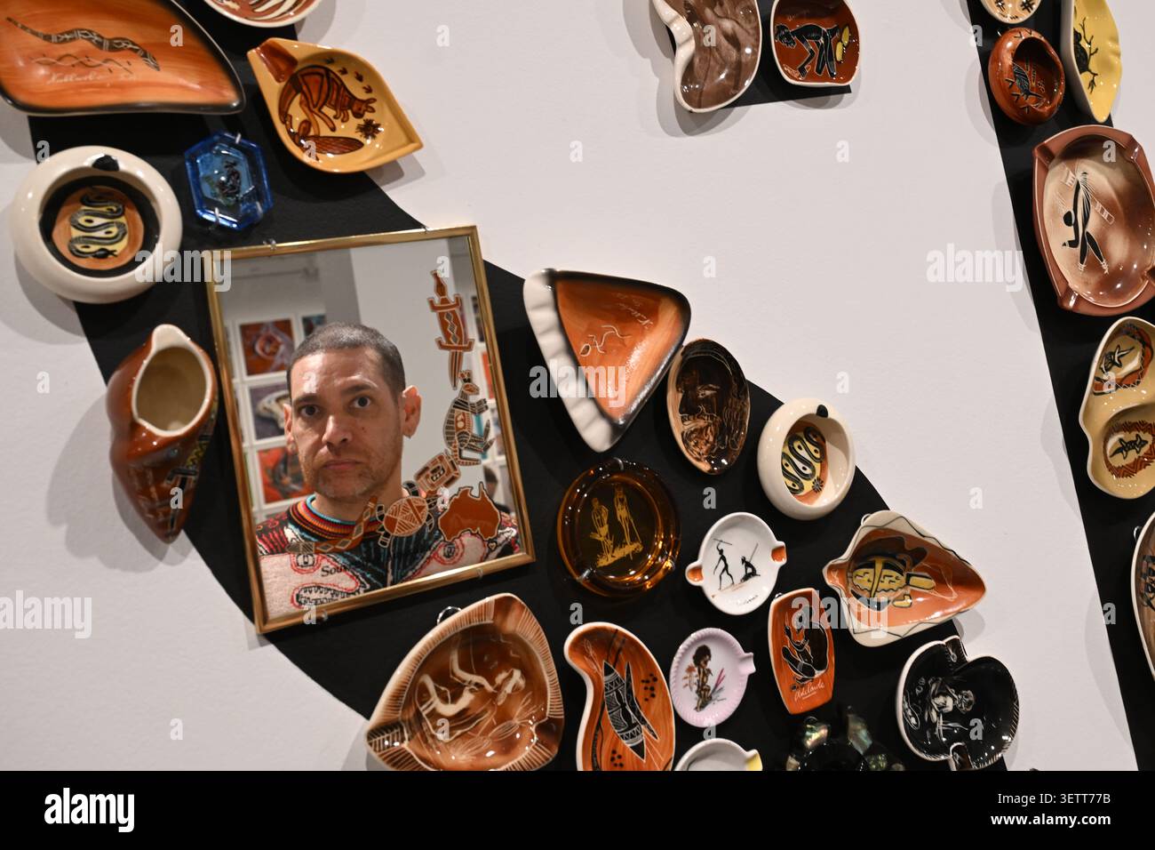 Artist Tony Albert is seen reflected in a mirror in his piece titled ...