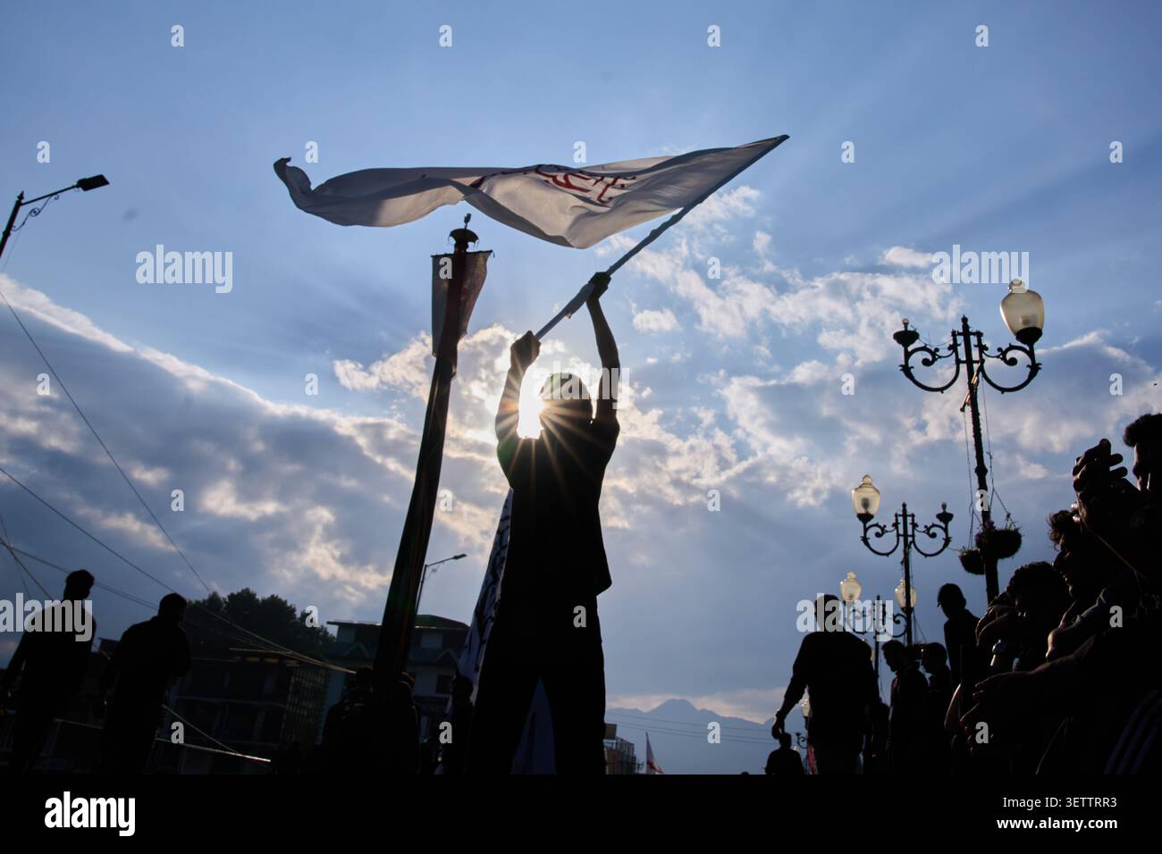 A man waves a flag that reads "O! Hussain, father of Abdullah" as ...