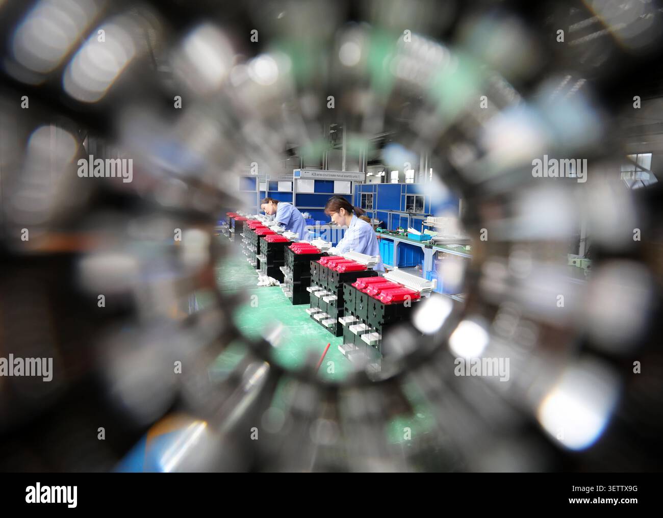 Workers assemble intelligent switch devices at a manufacturing ...