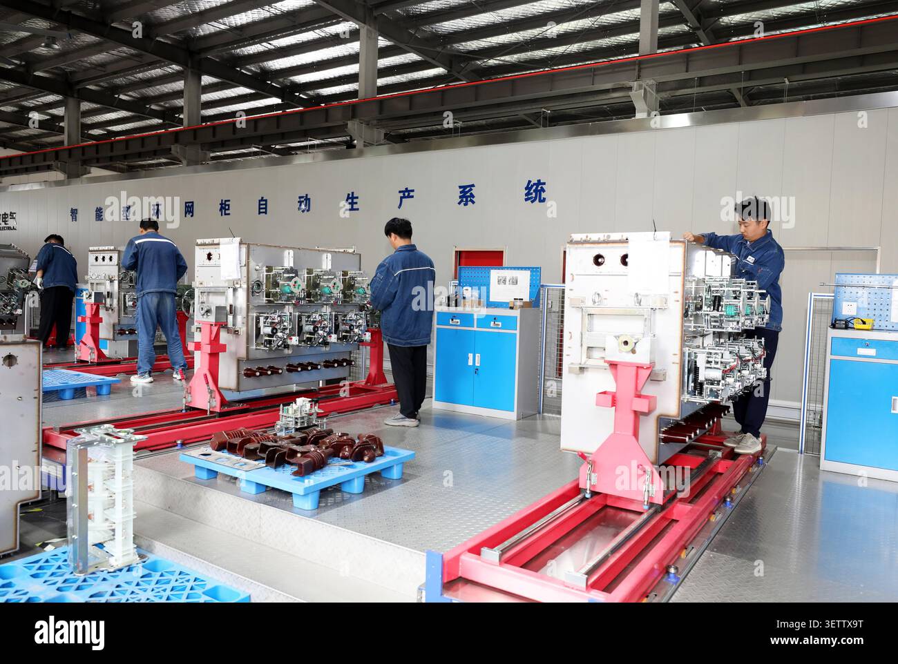 Workers assemble intelligent switch devices at a manufacturing ...