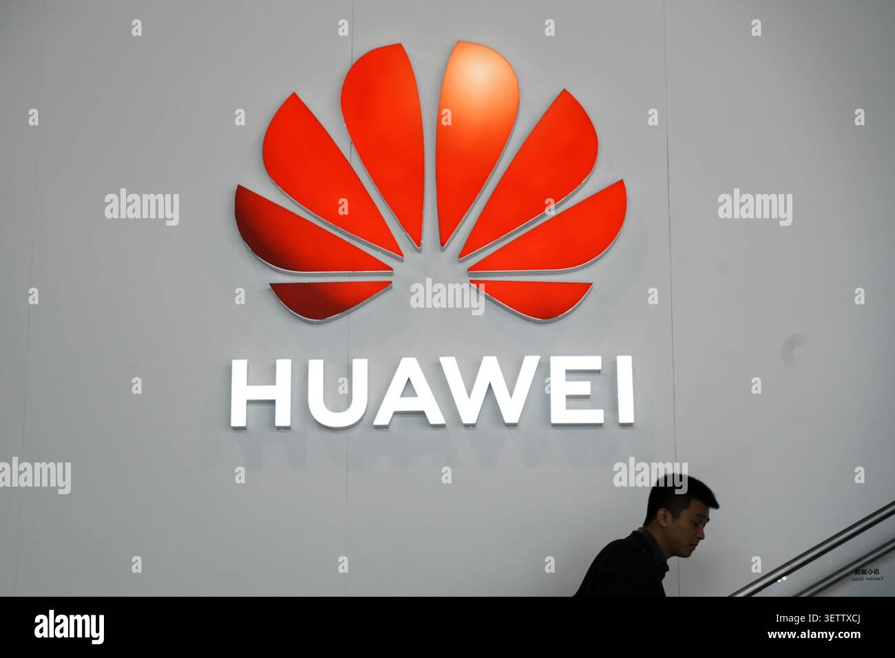 A man walks by a logo or Huawei during the MWC26 in Shanghai, China ...