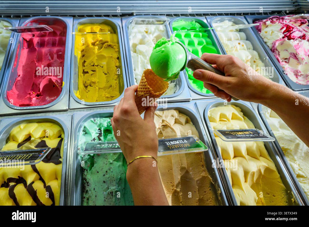Ice-cream is scooped onto a cone at an ice-cream shop in Beeskow ...
