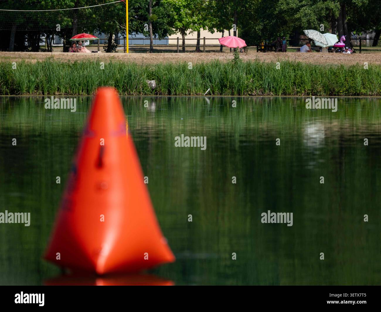 People enjoy a beach at Lac de Brionne, a swimming area, amid intense ...