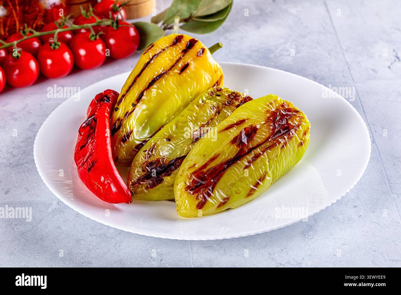 Grilled sweet peppers, red and yellow, served on white plate. Distinct ...