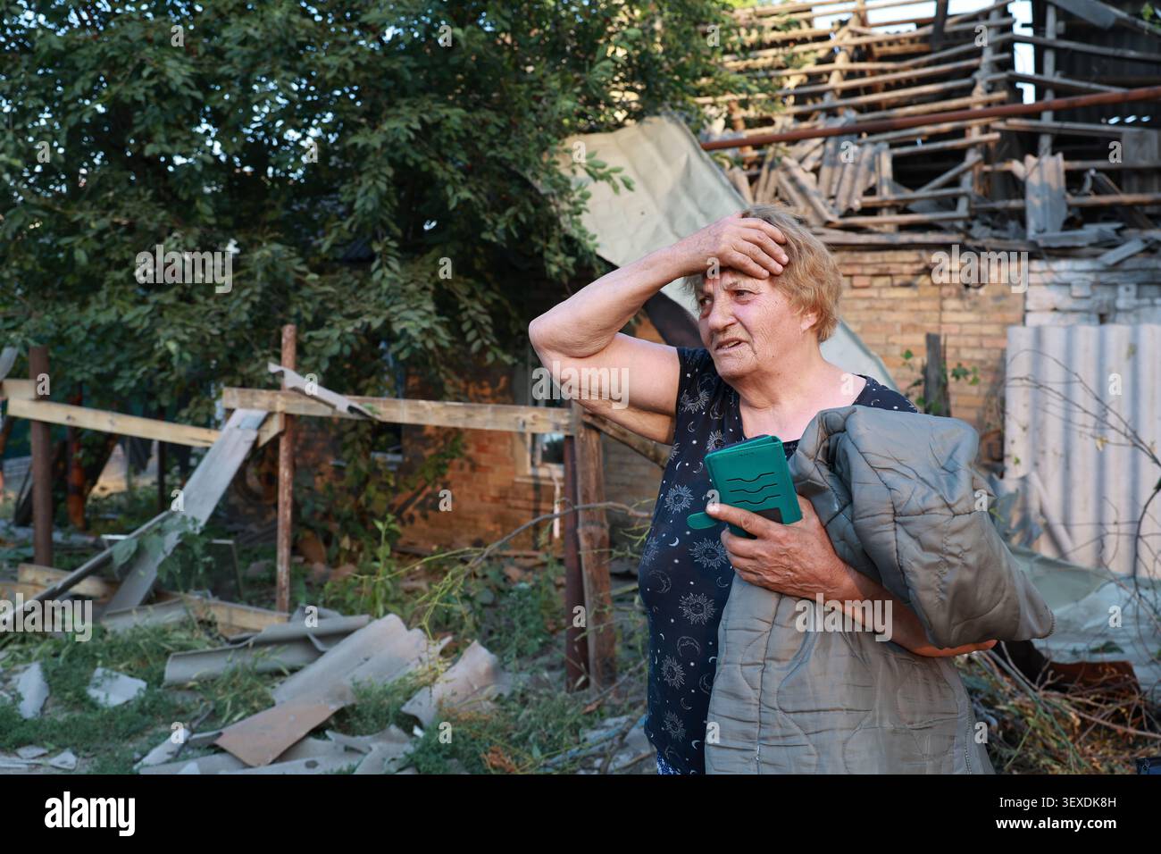 A woman reacts looking at her house damaged after a Russian strike on ...