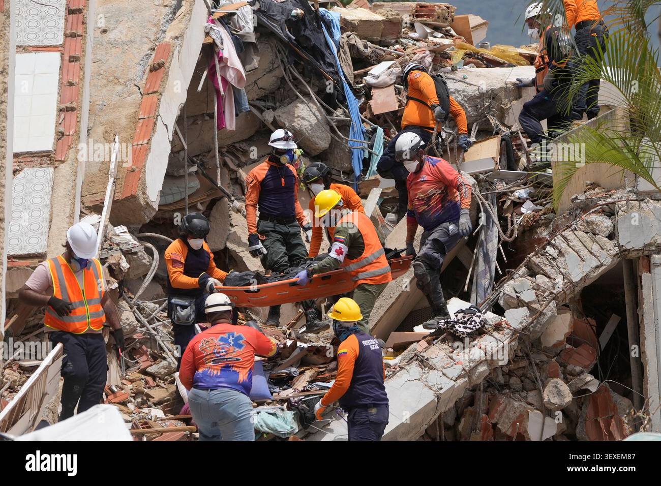 Rescue workers carry the body of an earthquake victim in La Guaira ...