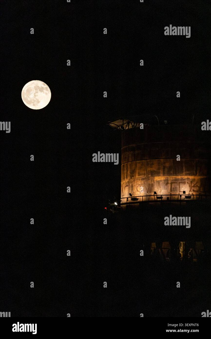 The Strawberry moon is seen rising next to a water tower in, Limassol ...