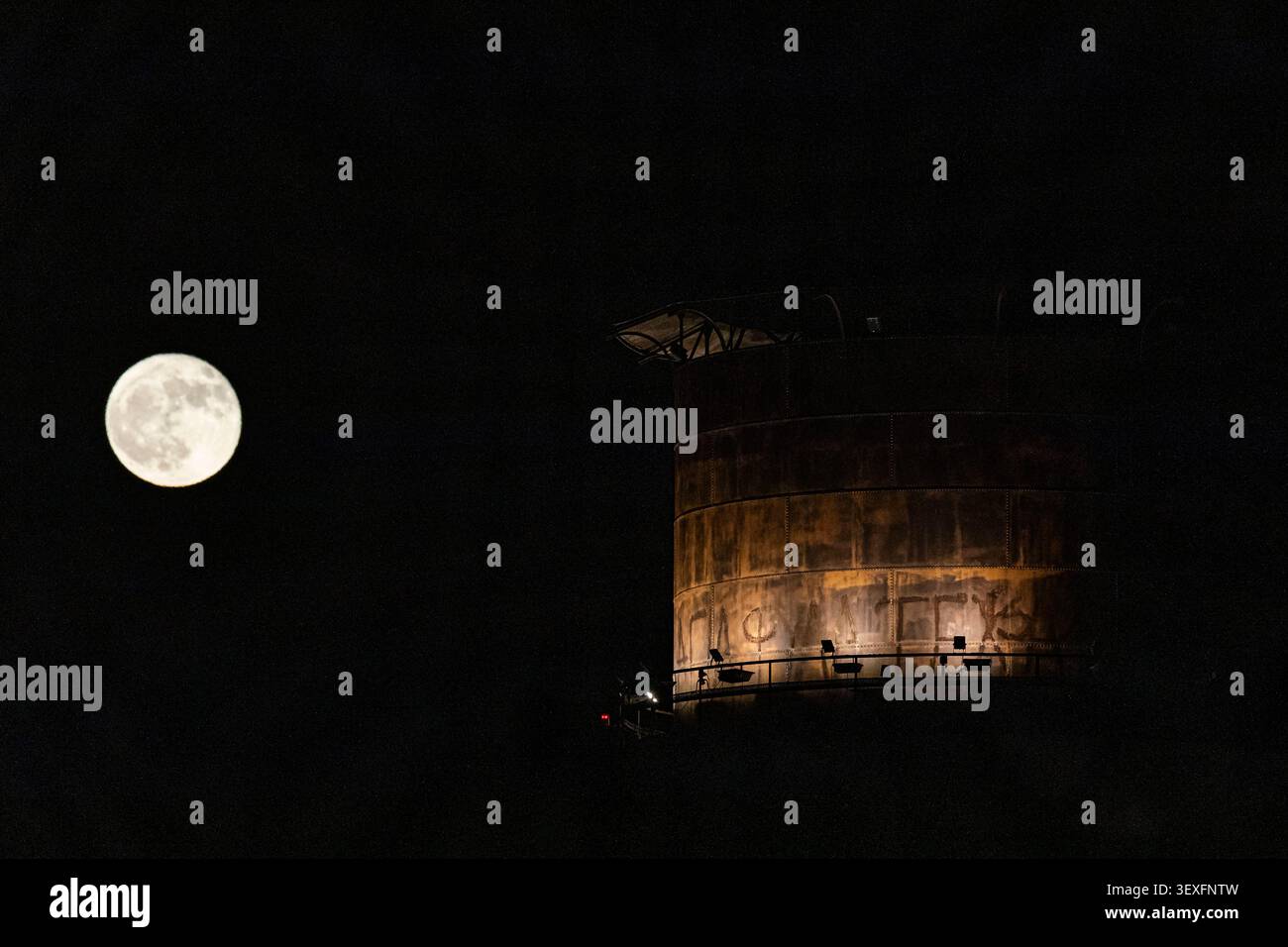 The Strawberry moon is seen rising next to a water tower in, Limassol ...