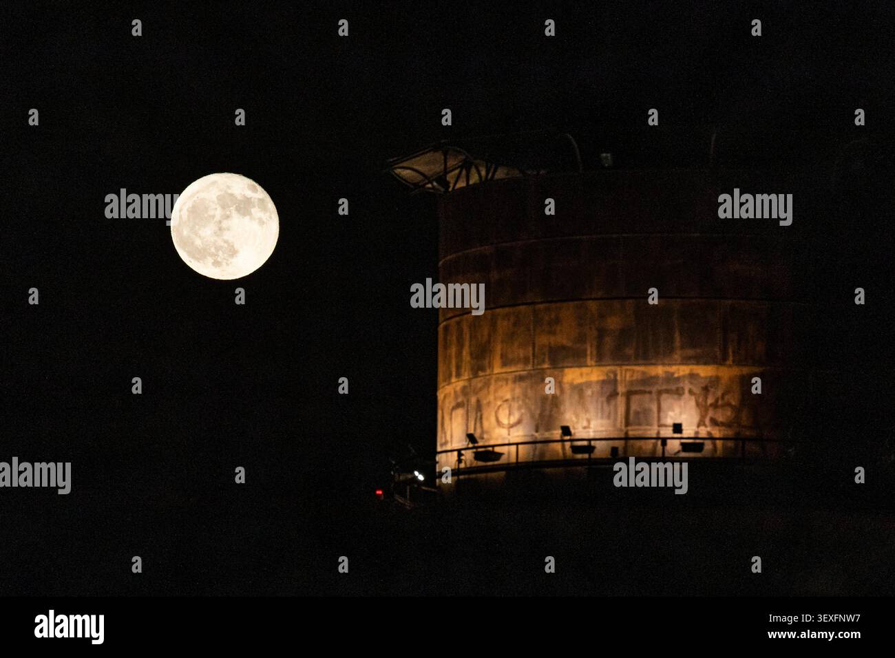 The Strawberry moon is seen rising next to a water tower in, Limassol ...