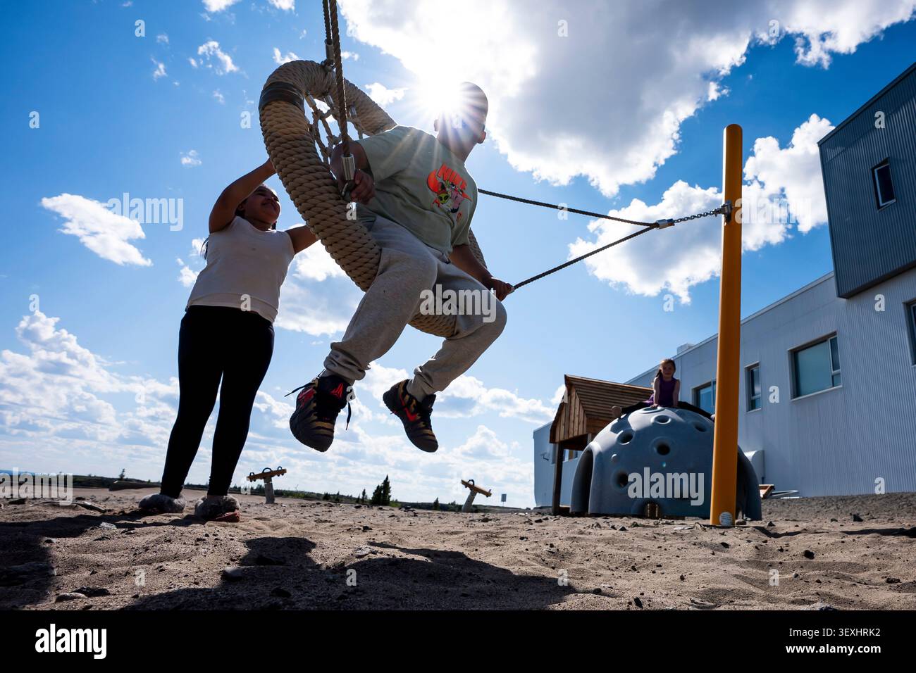 Alacie Saunders (10), pushes Aiden Stevenson (11) on a swing while Lisa ...