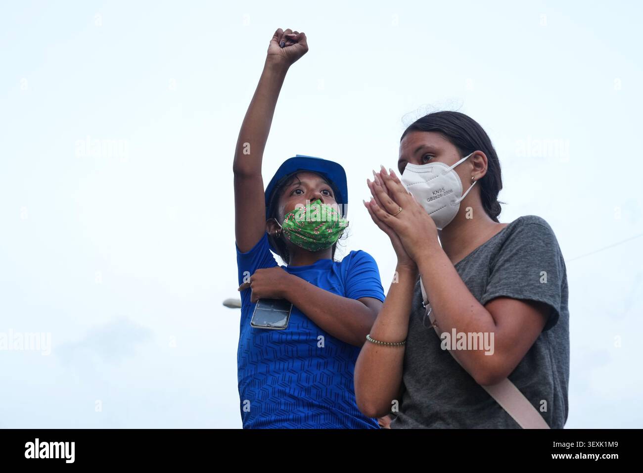 A woman raises her fist as a sign to keep silent during the rescue ...