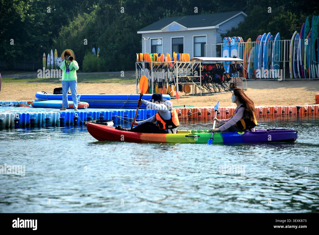 Tourists try paddleboarding and kayaking at the Olympic Water Park in ...