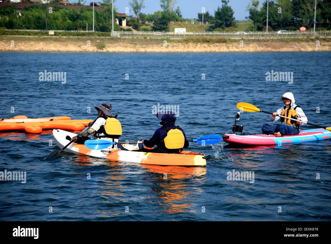 Tourists try paddleboarding and kayaking at the Olympic Water Park in ...