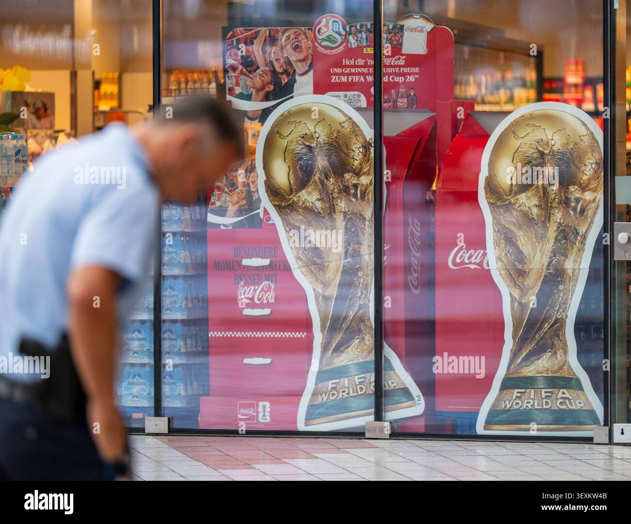 Munich, Germany. 01st July, 2026. A man walks past a store window at ...