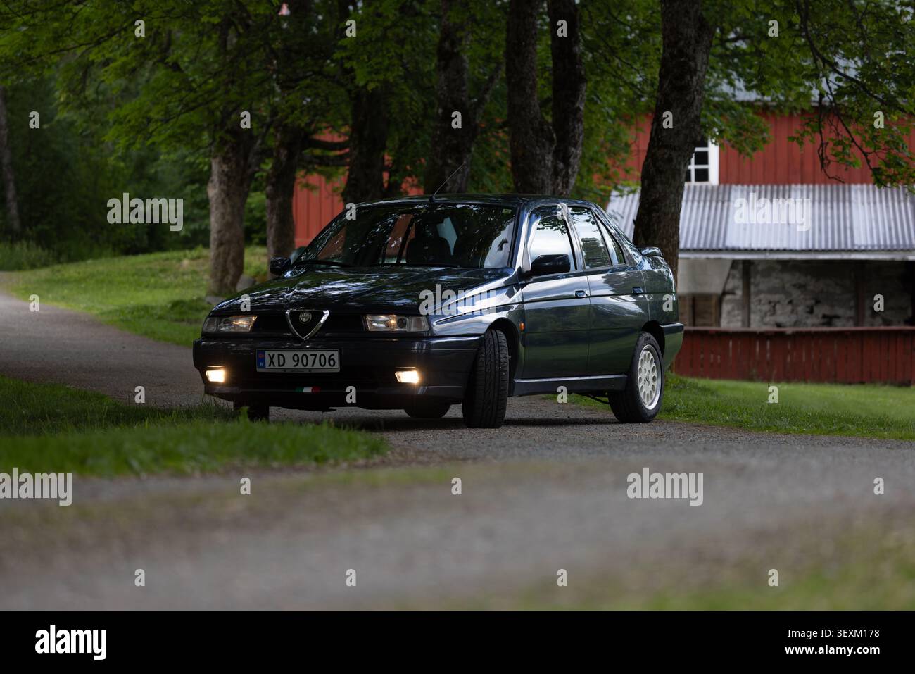 Steinkjer, Norway - June 15th 2024 - Dark Alfa Romeo 155 glides along ...