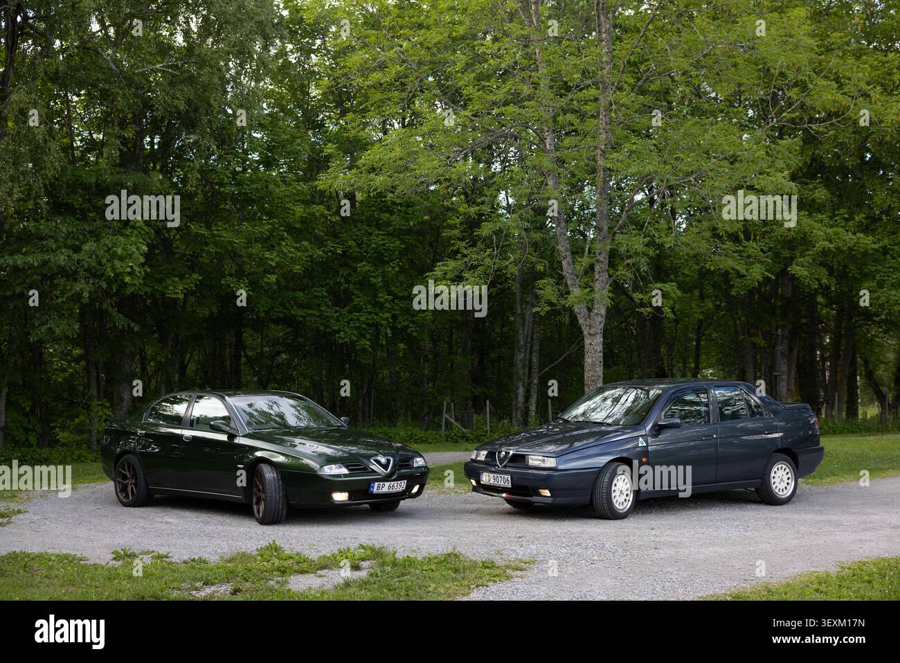 Steinkjer, Norway - June 15th 2024 - Two sedans parked on gravel near a ...