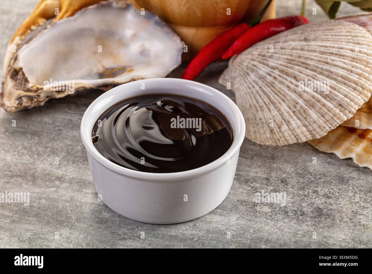 Dark glossy oyster sauce swirls in small white ceramic bowl. Oyster ...