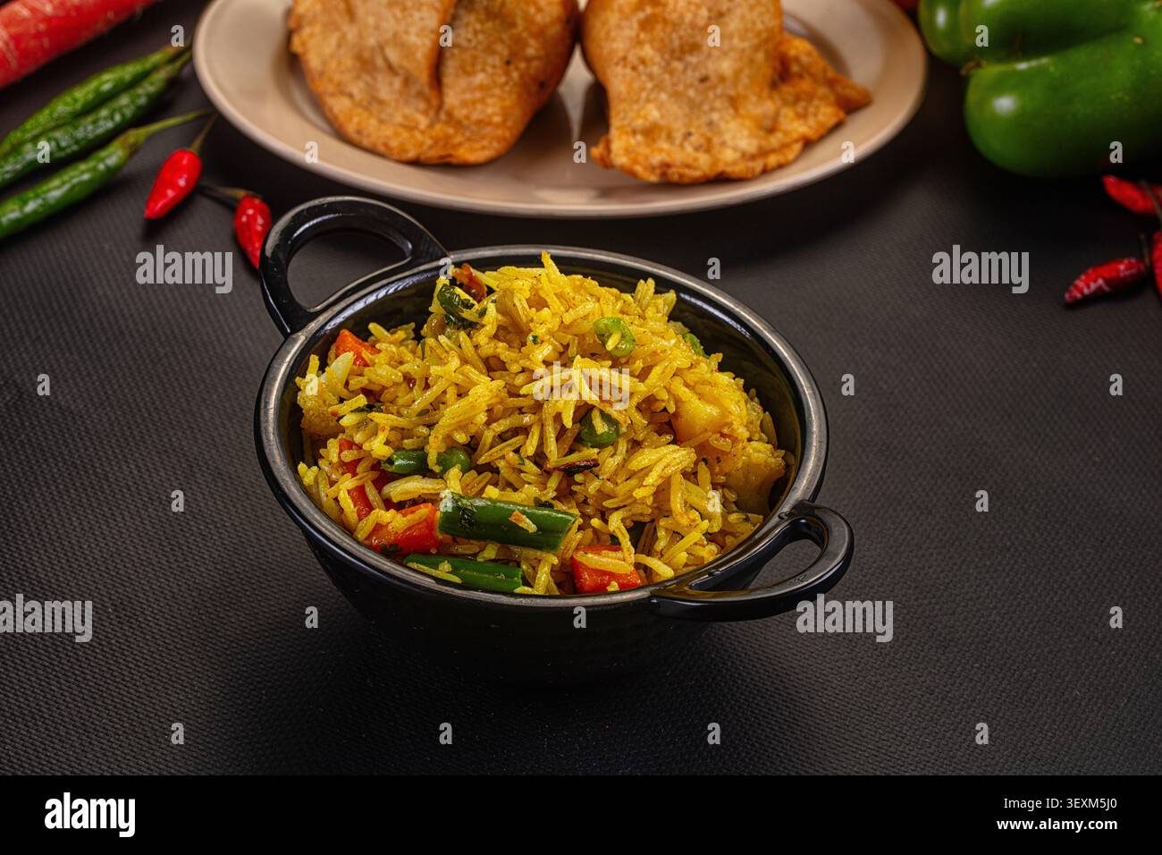 Vibrant yellow rice with green beans, red peppers, spices served in ...