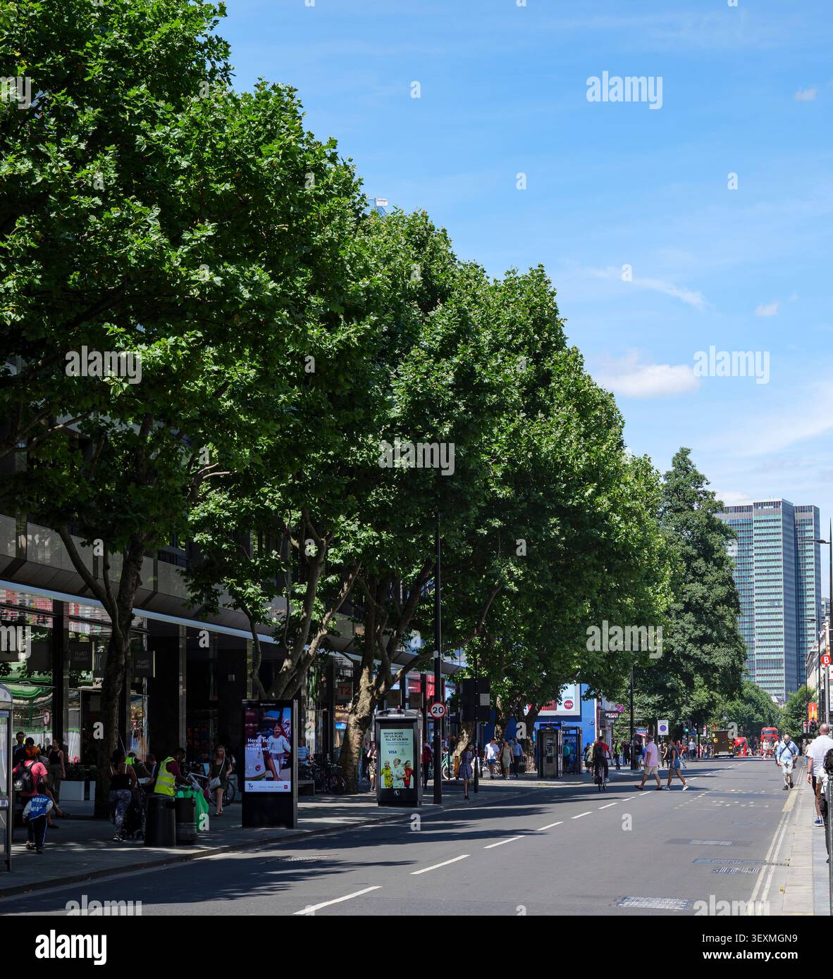 London - 07 14 2022: Tottenham Court Road tree‑lined street with modern ...