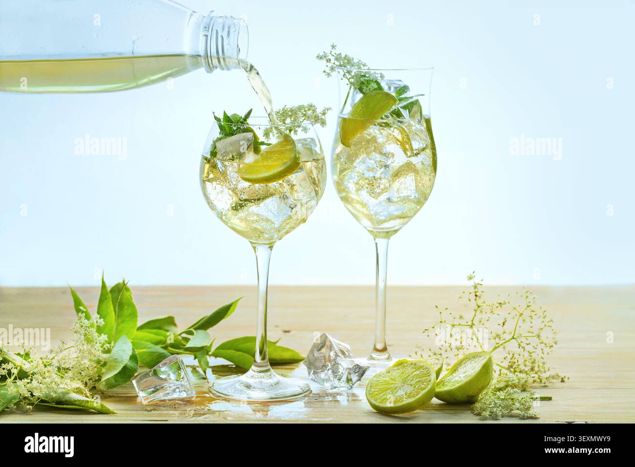Refreshing summer drink called Hugo Spritz is poured in two wine ...