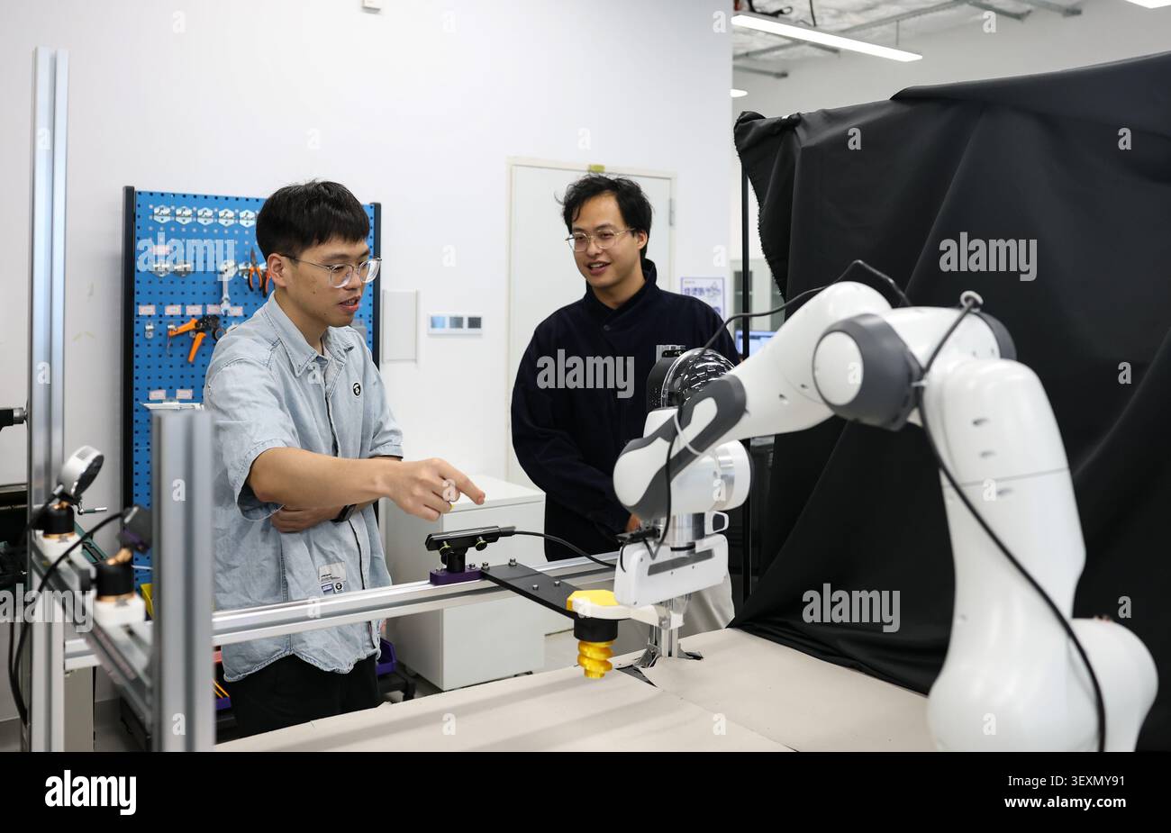 (260701) -- GUANGZHOU, July 1, 2026 (Xinhua) -- A student (L) talks ...