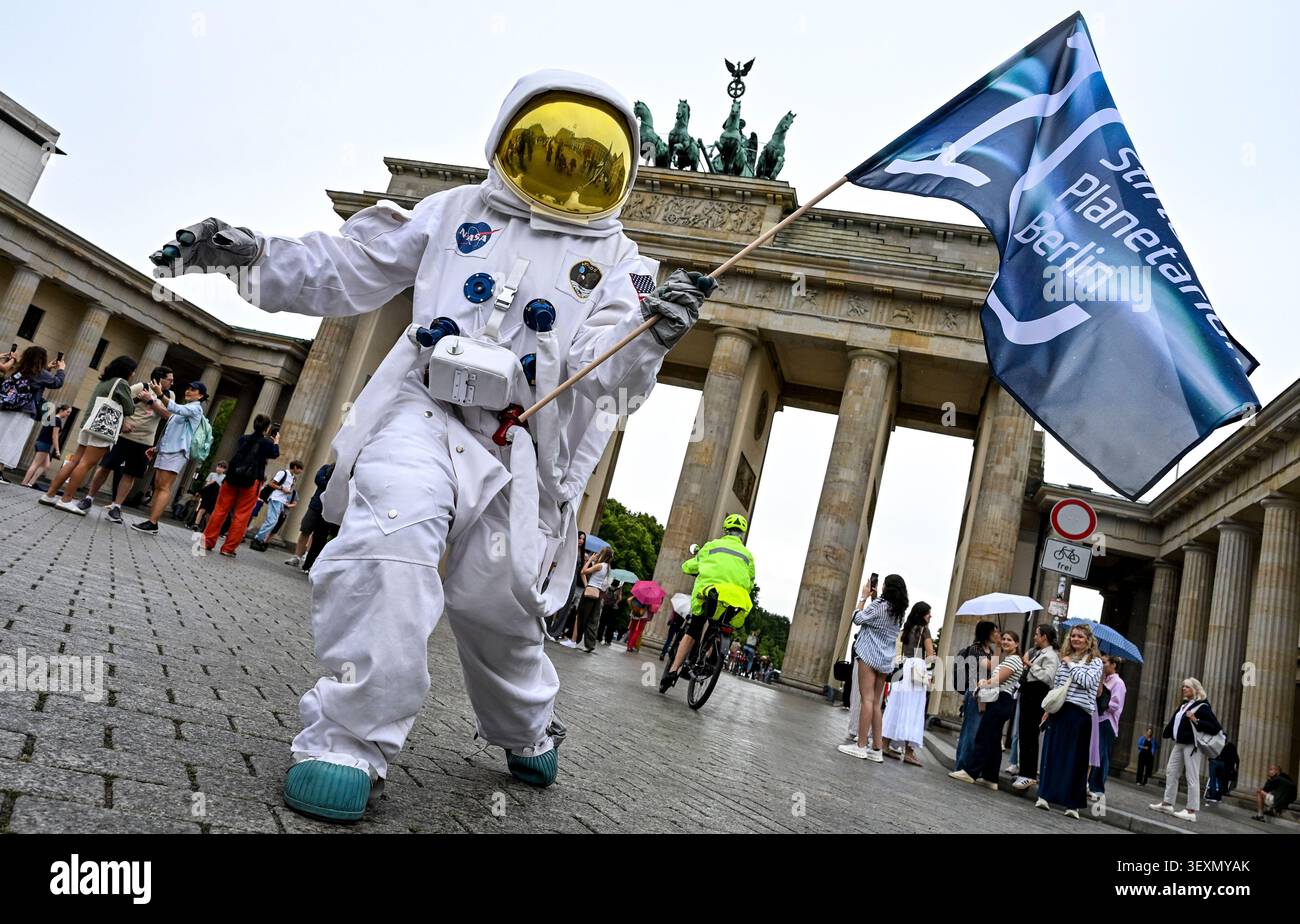 01 July 2026, Berlin: An actress dressed as an astronaut stands in ...