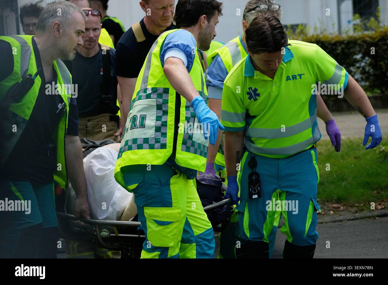 Rescue workers take a resident to an ambulance after an apartment block ...
