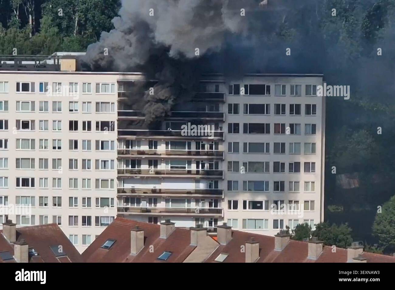 A resident stands on a balcony during an apartment block fire in ...