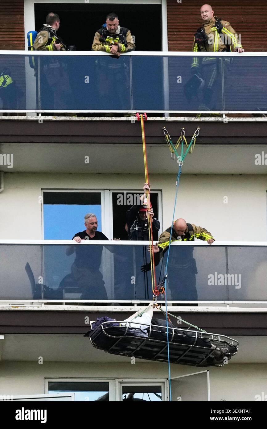 A person is evacuated from an upper floor after an apartment block fire ...