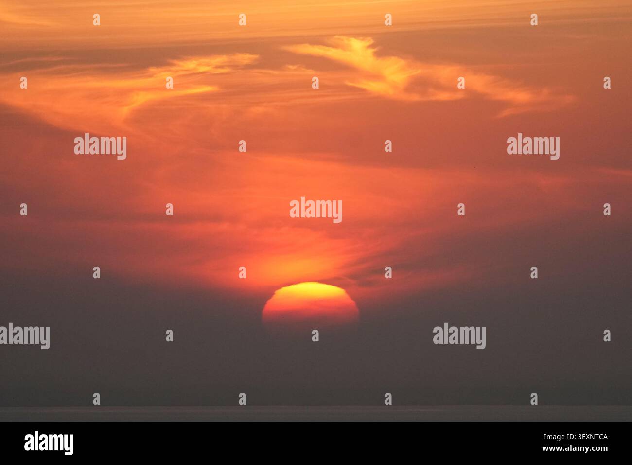 The sun rises over the Tagus river in Lisbon where temperature is ...