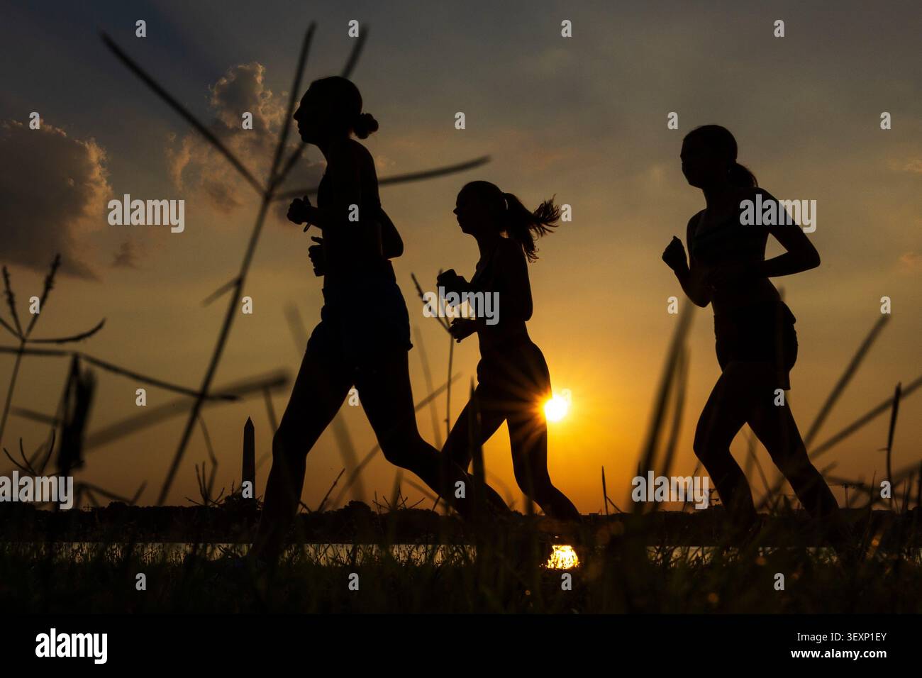 People jog along the Potomac River as the sun rises near the Washington ...
