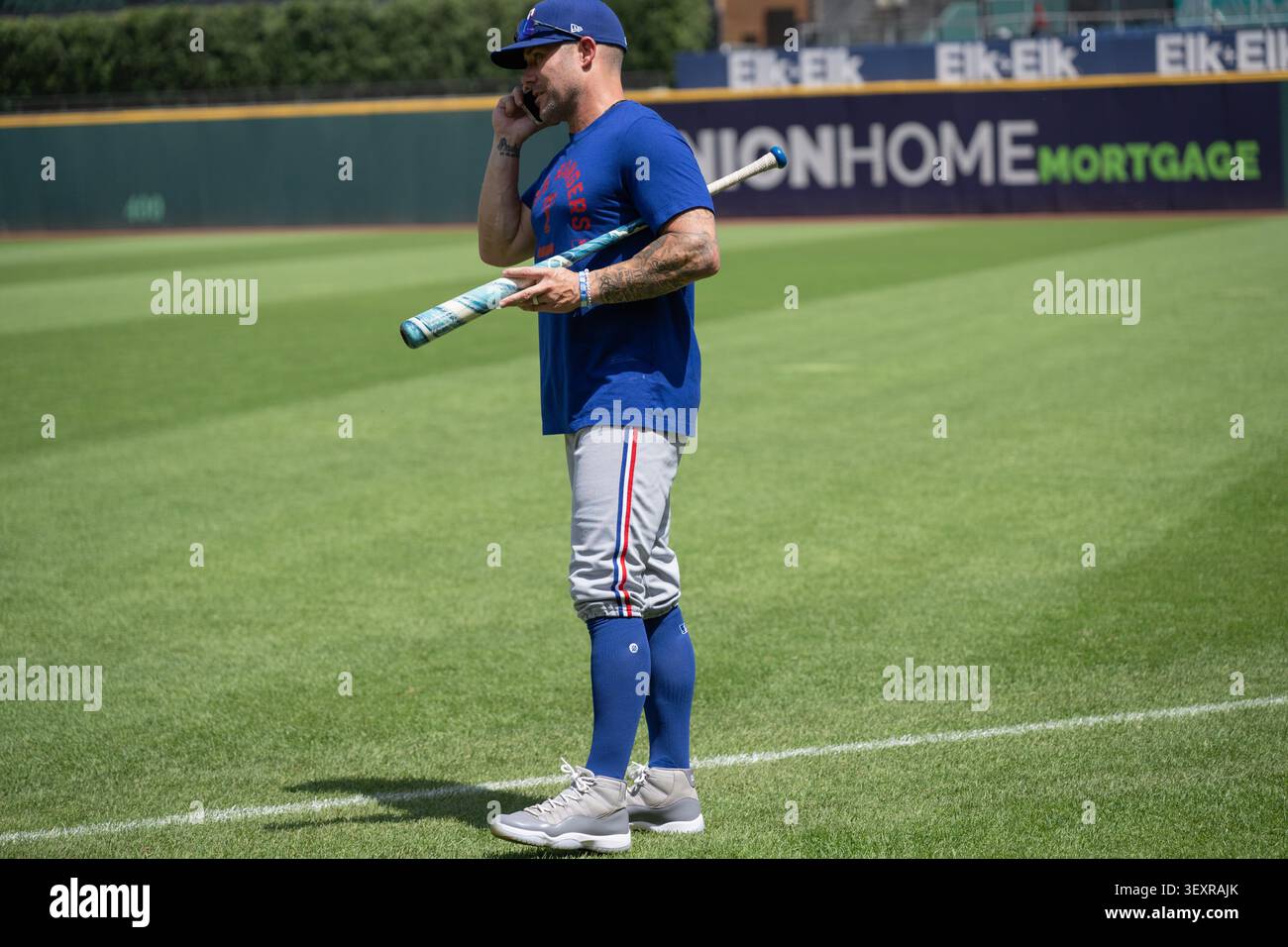 Texas Rangers manager Skip Schumaker talks on his phone as he walks the ...