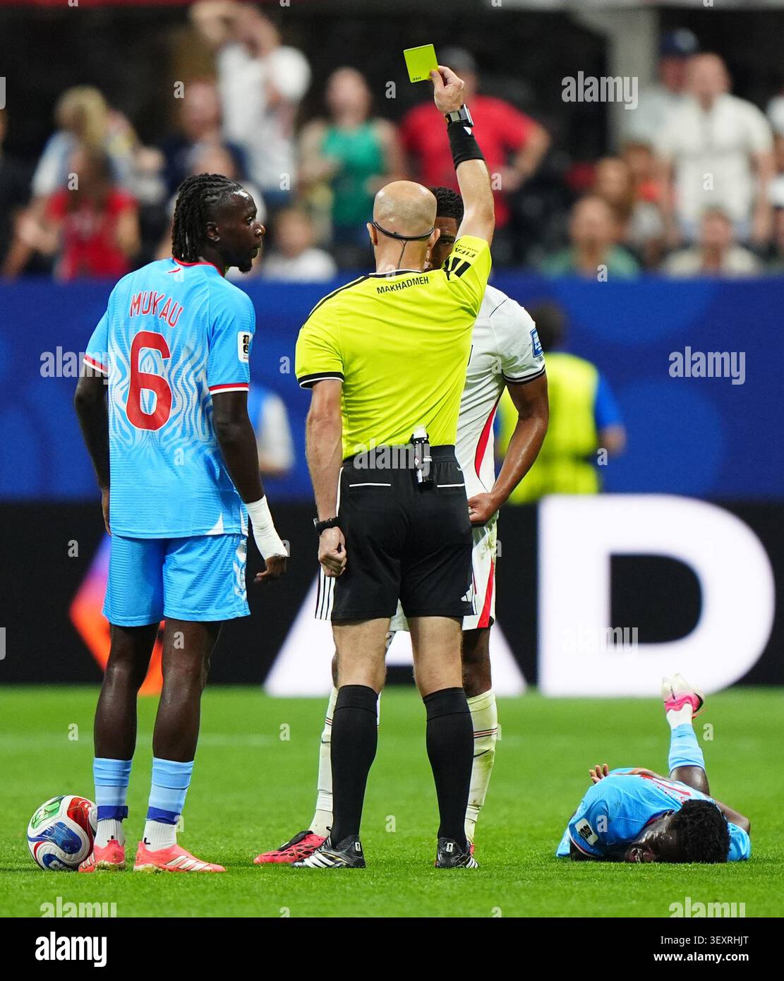 Referee Adham Mohammad shows a yellow card to England's Jude Bellingham ...