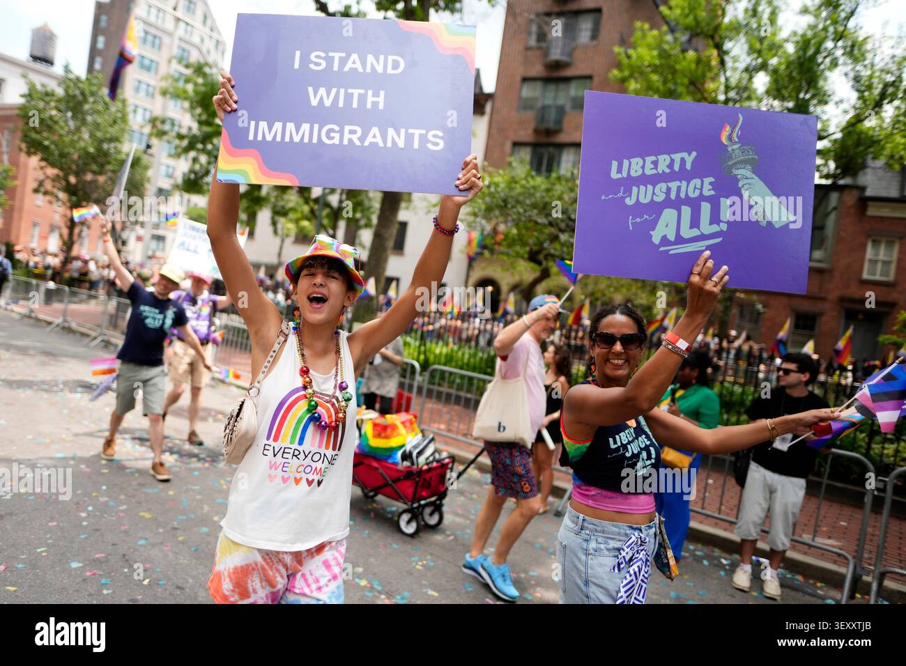 A parade-goer holds a sign that reads "I STAND WITH IMMIGRANTS" during ...