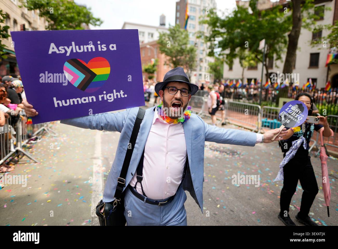A parade-goers holds a sign that reads "Asylum is a human right" during ...