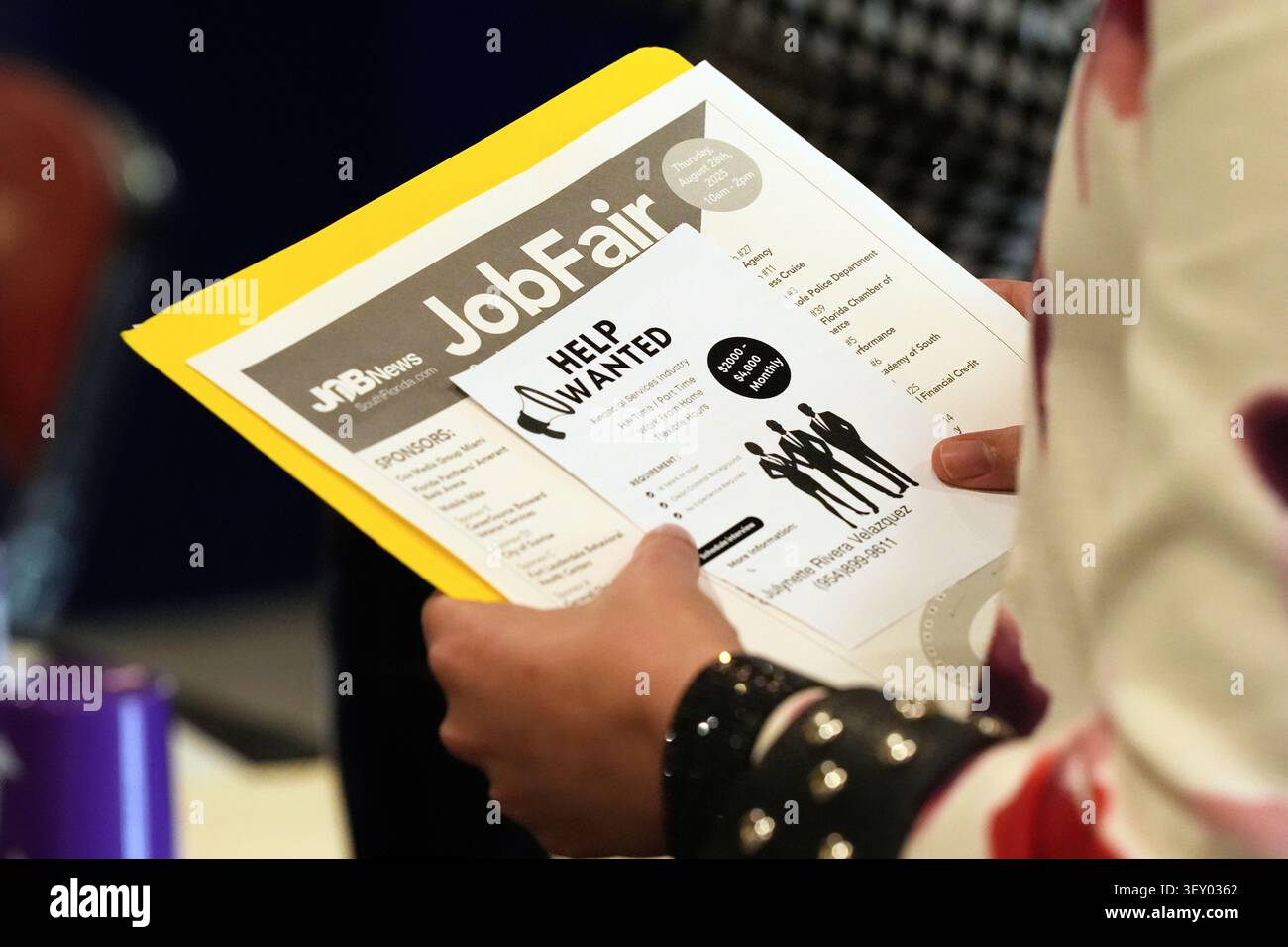 FILE - A job seeker waits to talk to a recruiter at a job fair Aug. 28 ...