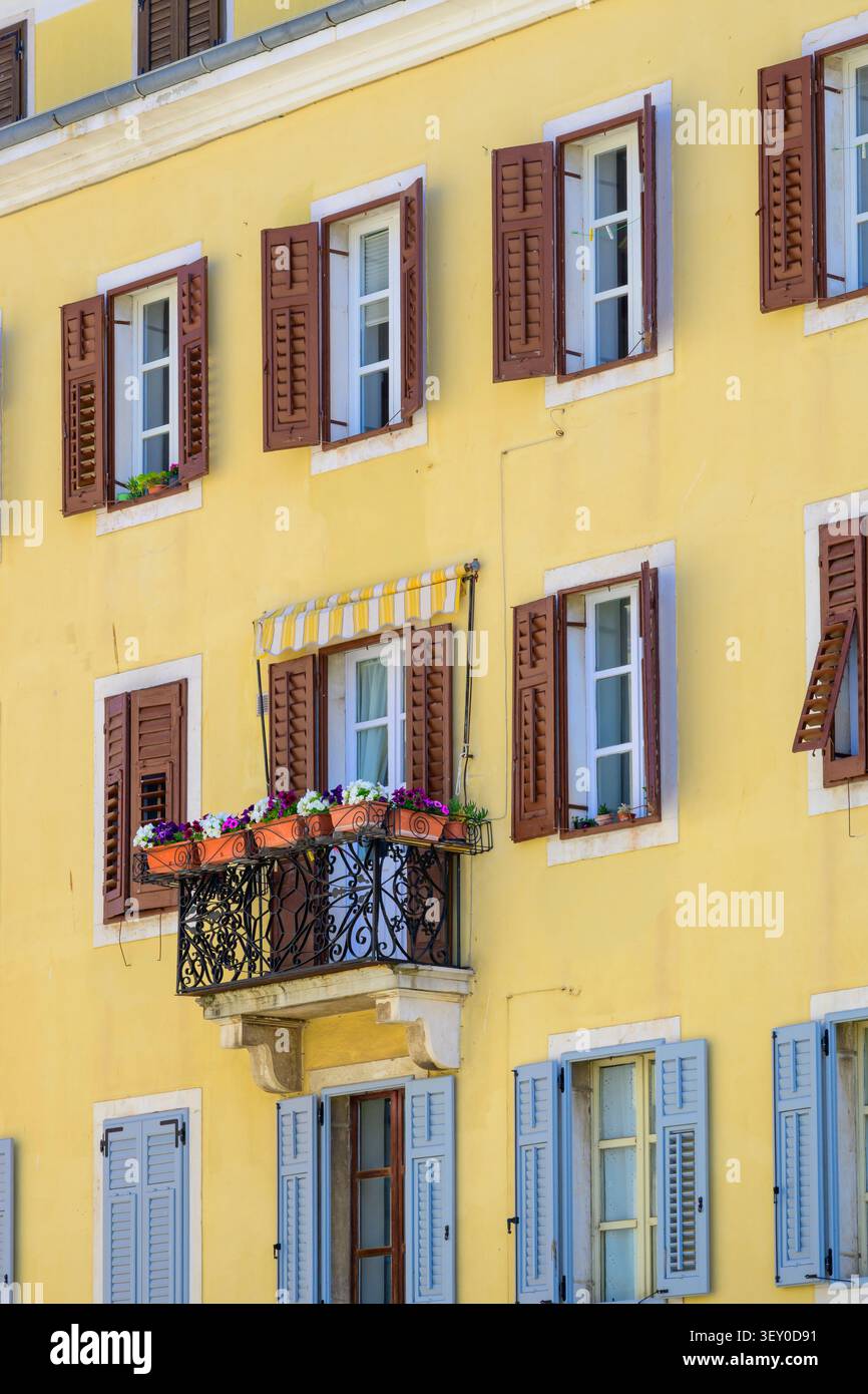 Windowboxes full of petunias decorate a balcony of a residence in old ...