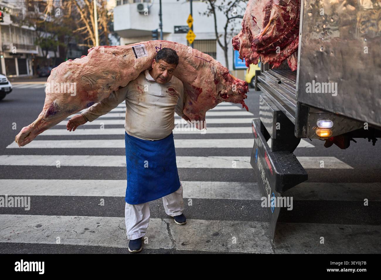 Gustavo Carbone unloads a beef carcass at a butcher shop in Buenos ...