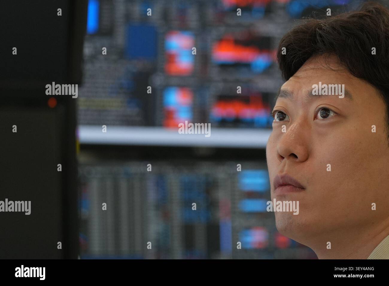 A dealer watches computer monitors at a dealing room of Hana Bank in ...