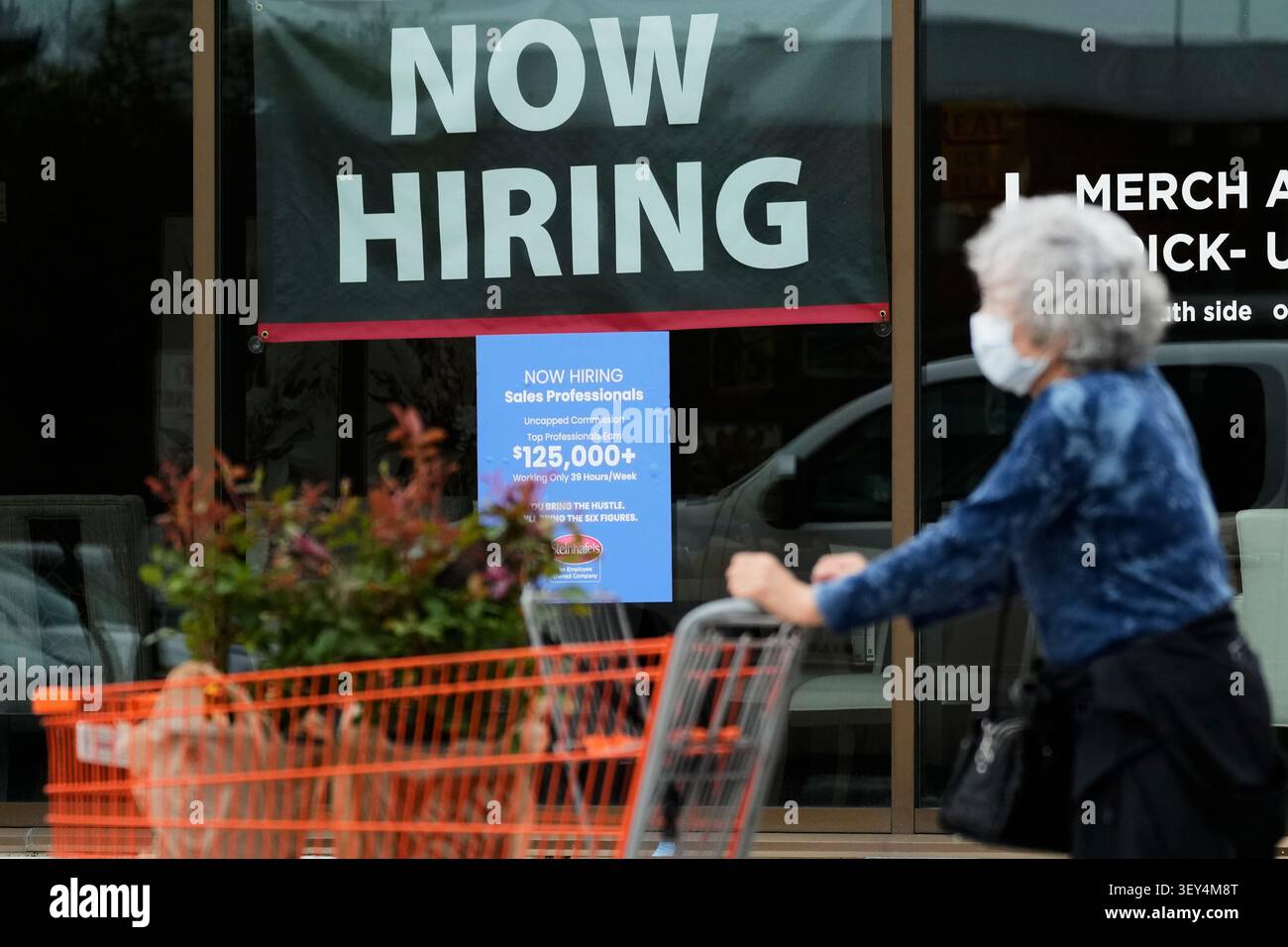 FILE - Hiring sign for sales professionals is displayed at a store, in ...
