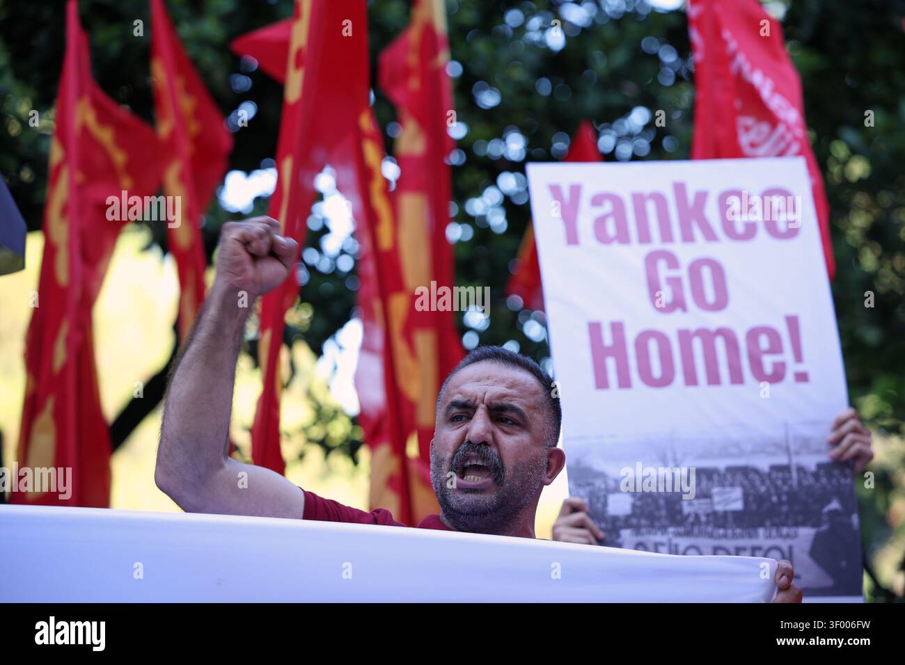 A protestor holds a sign while others wave flags during a demonstration ...