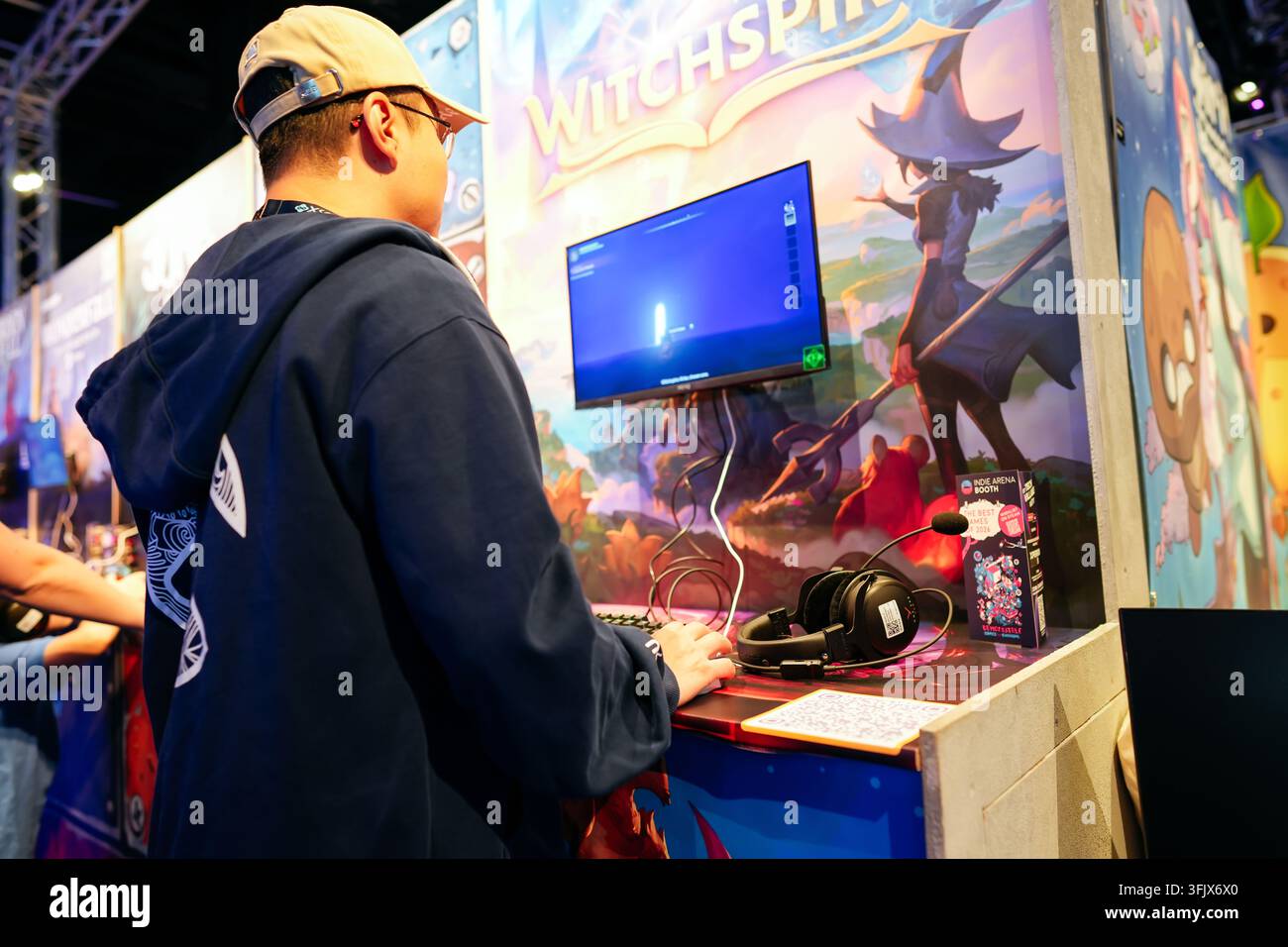 Cologne, Germany - August 26, 2026: Visitor operates a computer beside ...