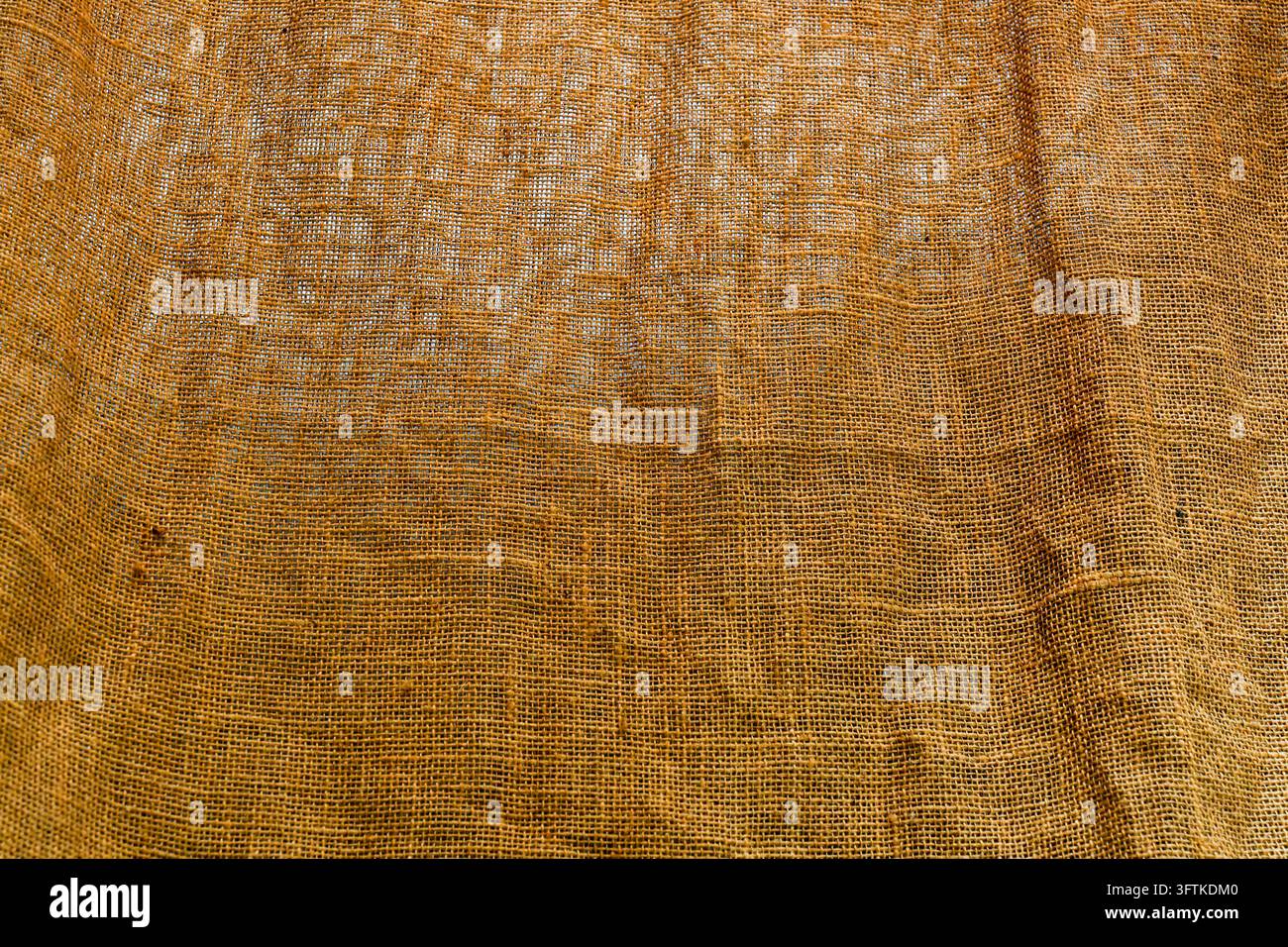 A woven burlap fabric texture with warm brown color, rough natural ...