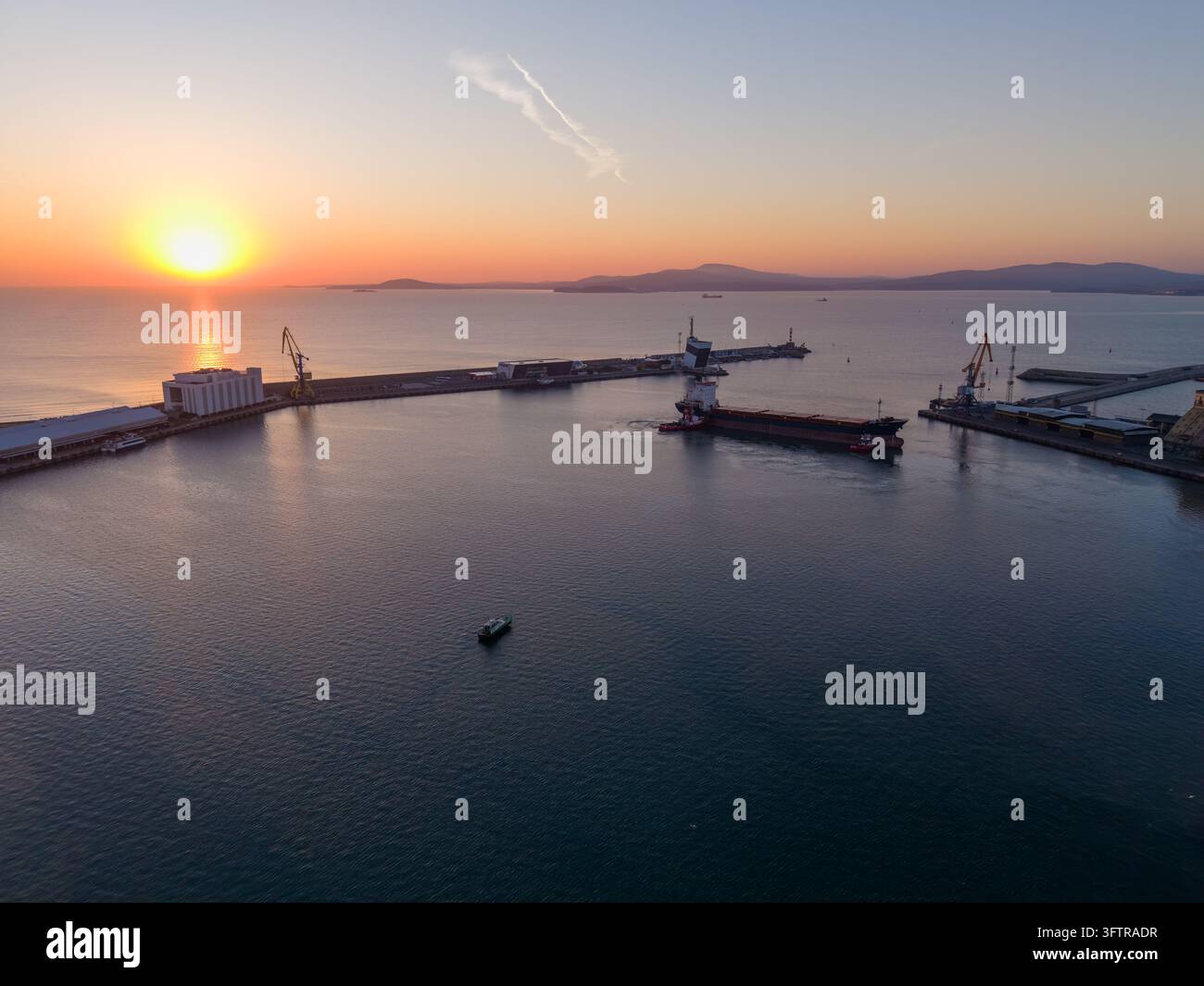 Aerial view of the Port of Burgas at sunrise, featuring a cargo ship ...