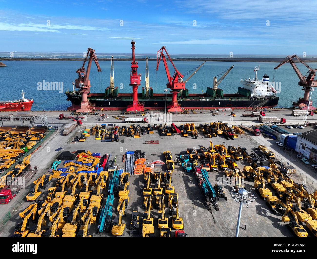 A cargo ship loads domestically-made engineering vehicles for export to ...