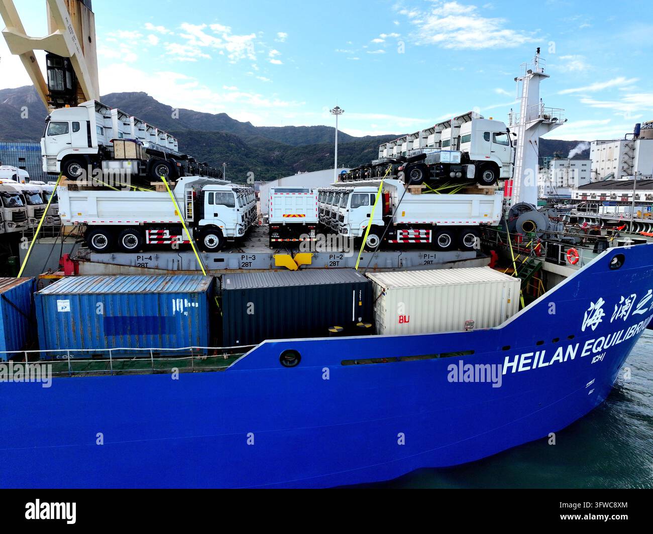 A cargo ship loads domestically-made engineering vehicles for export to ...