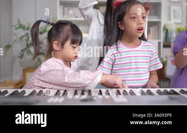 A group children doing activities singing and dancing in the classroom ...