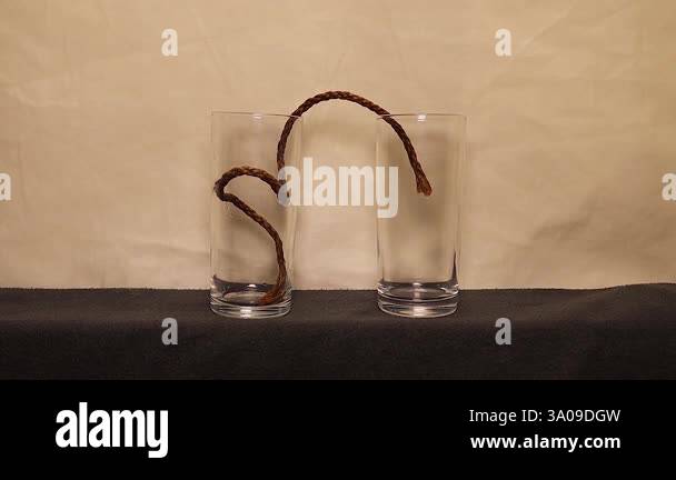 Capillary tube effect in physics: Water transfer from a full glass to ...