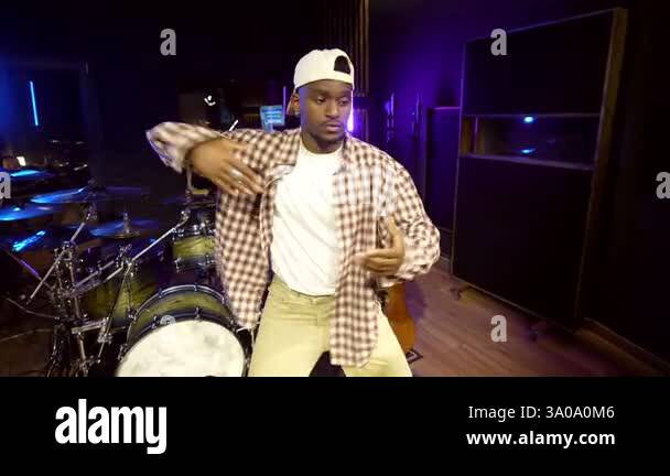 Dynamic black musician performing energetic dance moves inside ...
